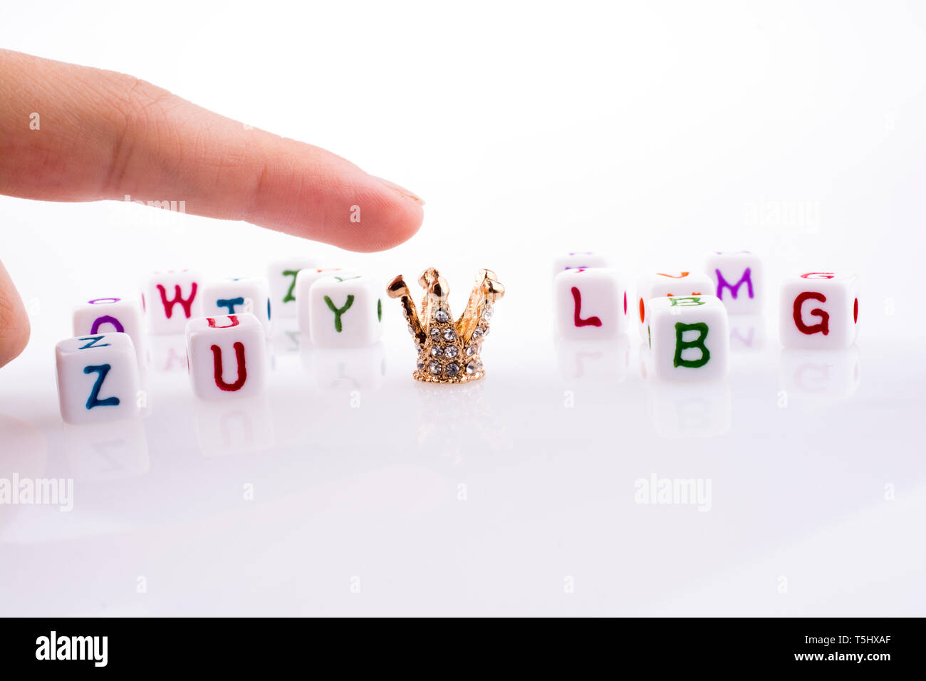Hand pointing at Crown between Letter cubes on a white background Stock ...