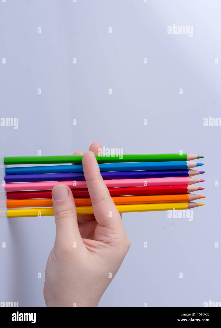 Hand holding color Pencils placed on a white background Stock Photo - Alamy