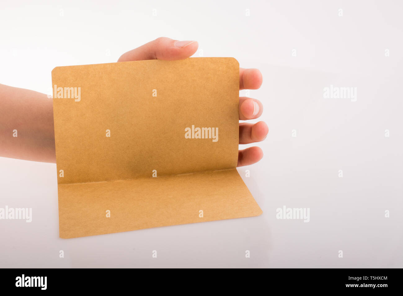Hand holding a sheet of paper on a white background Stock Photo - Alamy