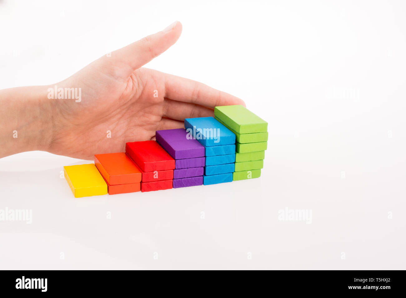 Hand playing with colored domino on white background Stock Photo - Alamy