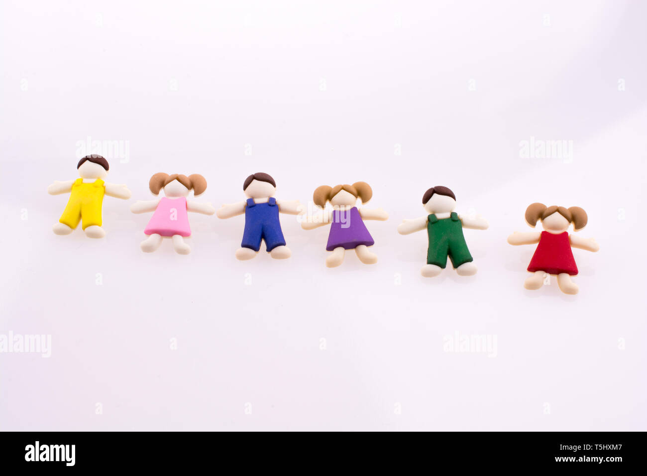Colorful dressed children figures on a white background Stock Photo - Alamy