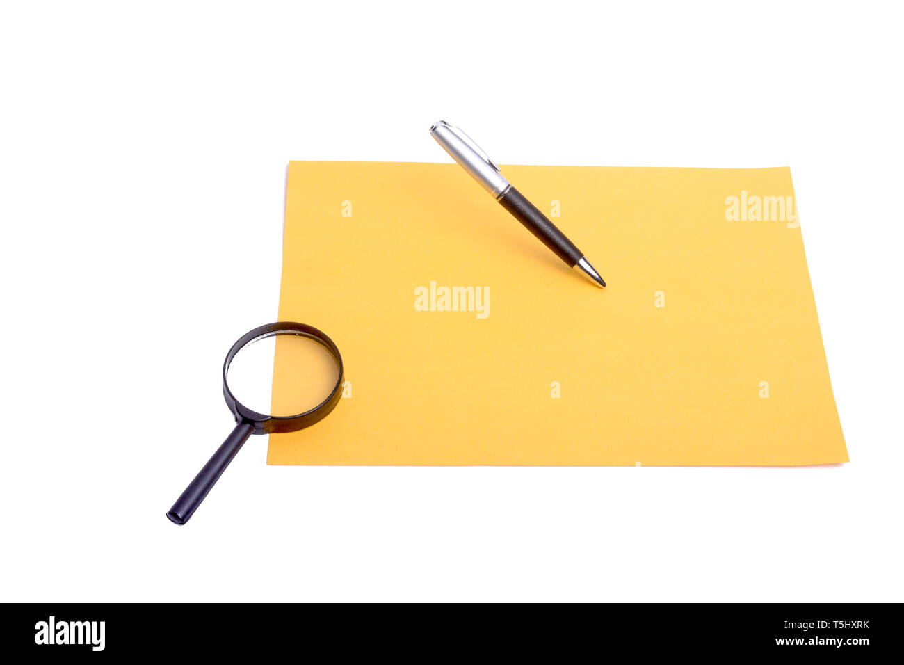 Pen and magnifying glass placed on yellow paper Stock Photo - Alamy