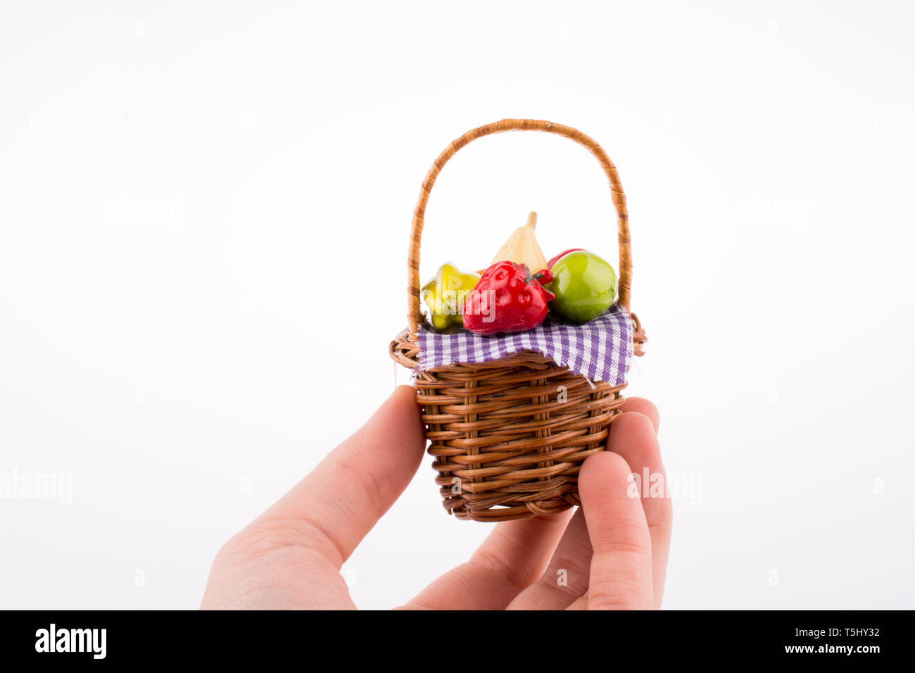 Hand holding a fruit basket on a white background Stock Photo - Alamy