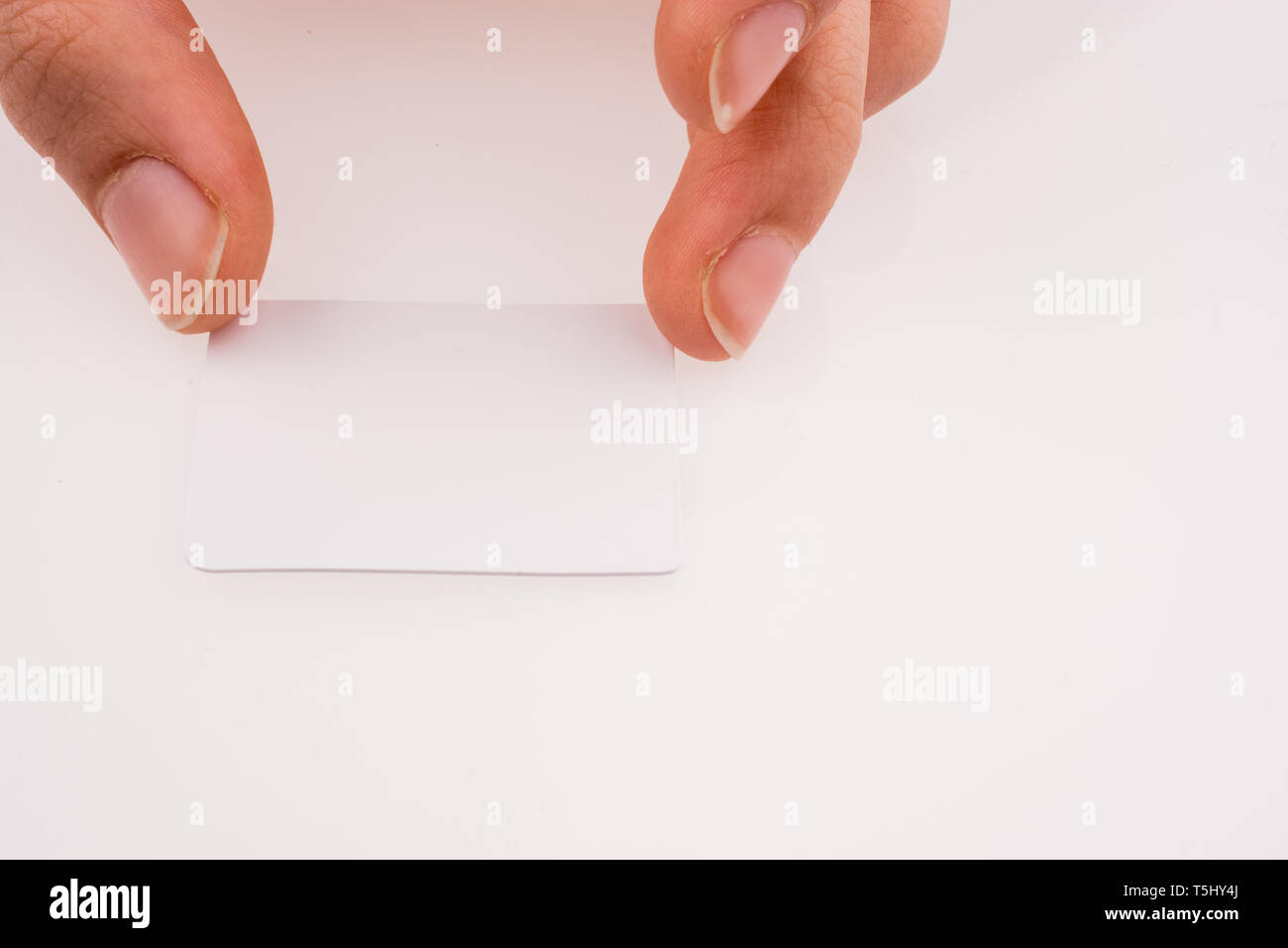 Hand holding a piece of paper on a white background Stock Photo - Alamy