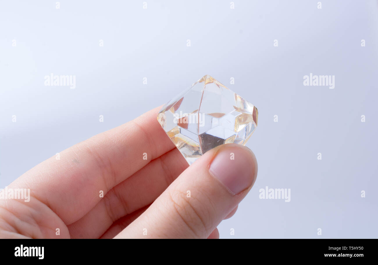 Hand holding a transparent diamond on a white background Stock Photo ...