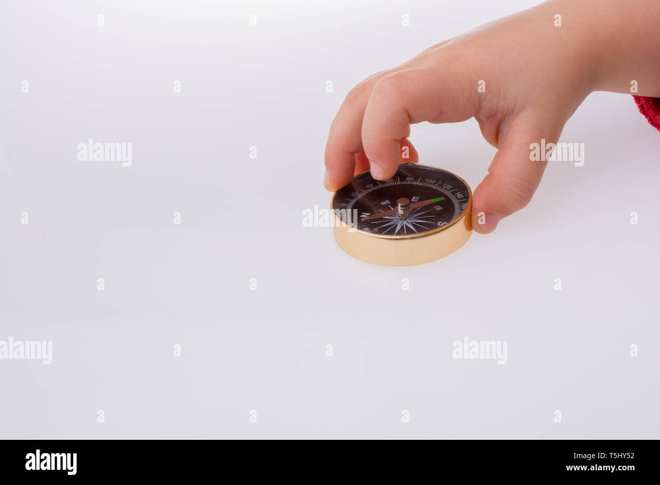 Child hand holding a compass on a white background Stock Photo - Alamy