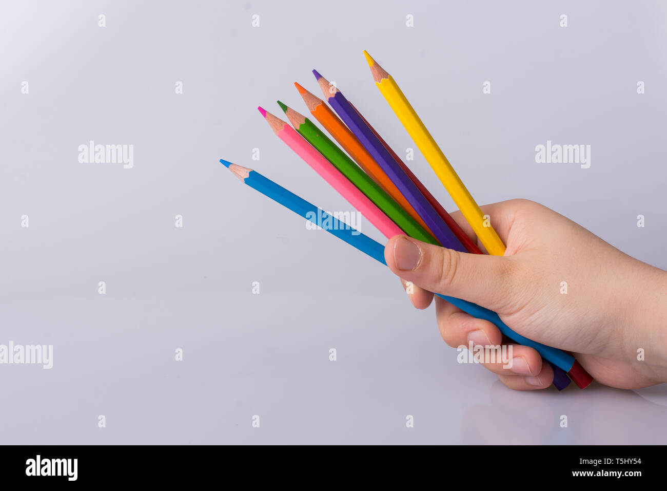 Hand holding color Pencils placed on a white background Stock Photo - Alamy