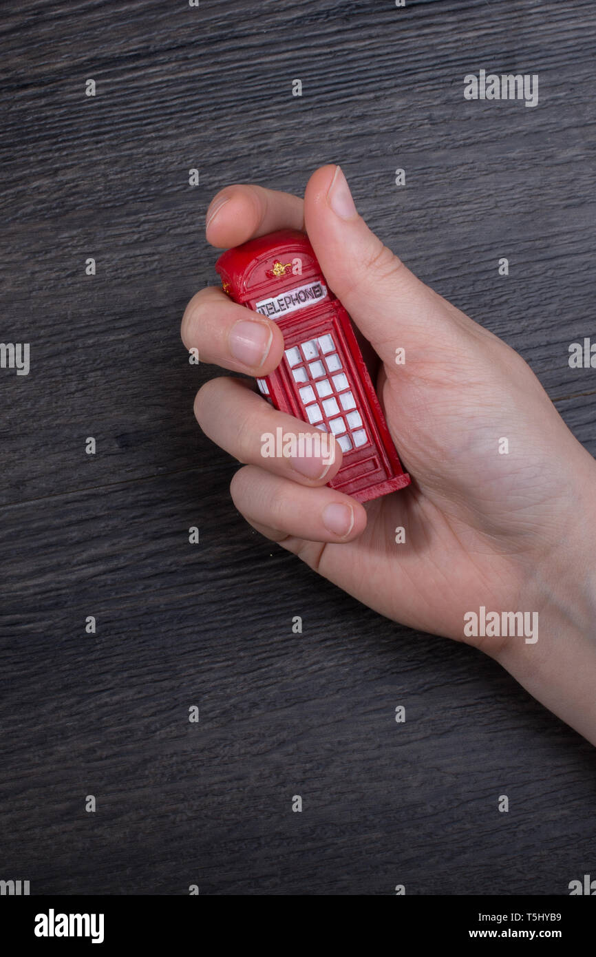 Hand holding a phone booth on a dark background Stock Photo - Alamy