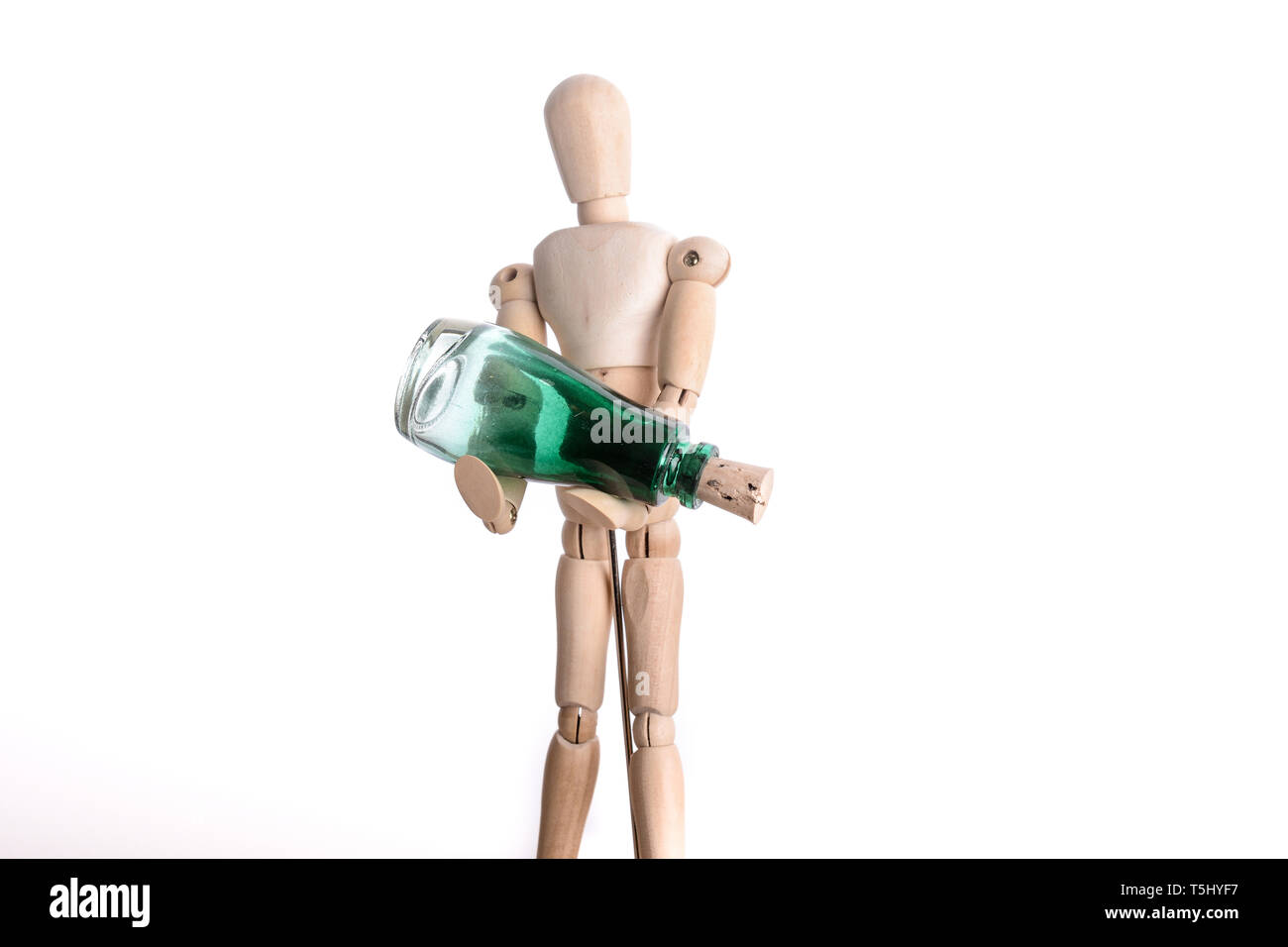 Wooden man holding a green bottle on white background Stock Photo - Alamy