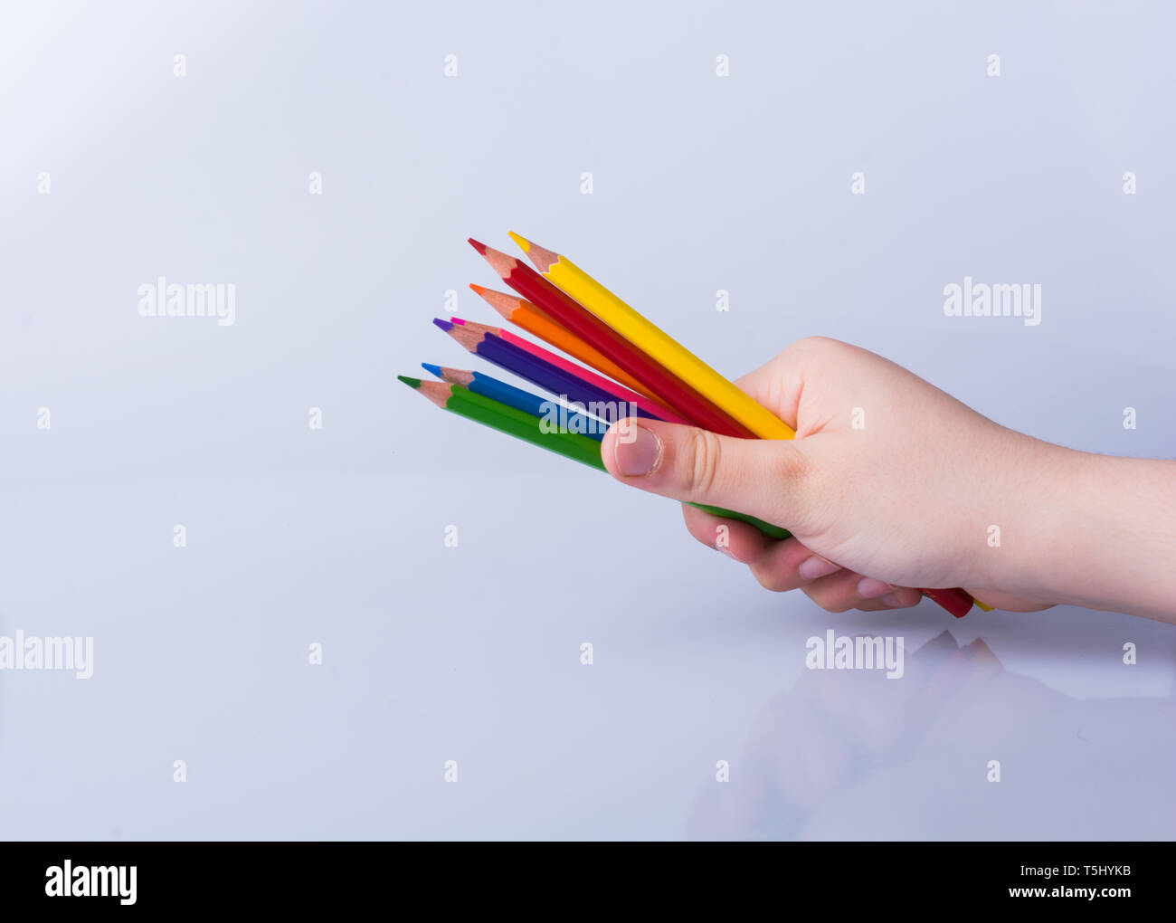 Hand holding color Pencils placed on a white background Stock Photo - Alamy