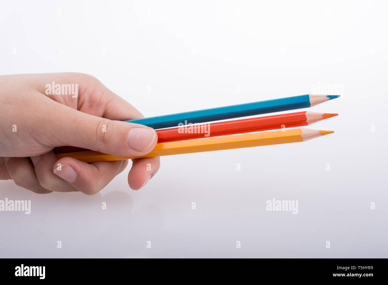 Hand holding color pencils on a white background Stock Photo - Alamy
