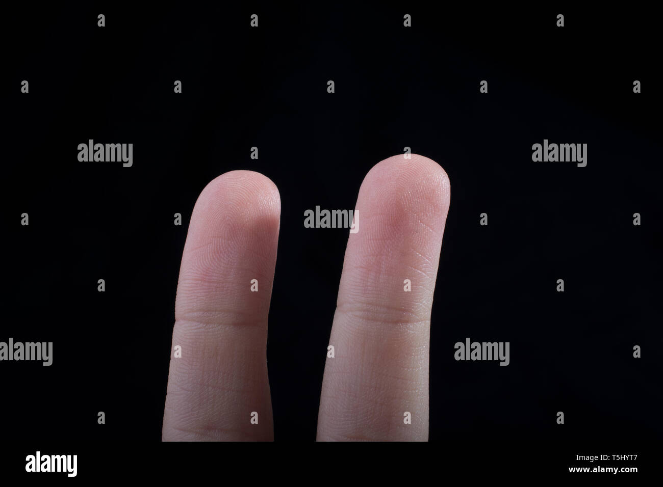 Two fingers of a child hand partly seen in black background Stock Photo ...