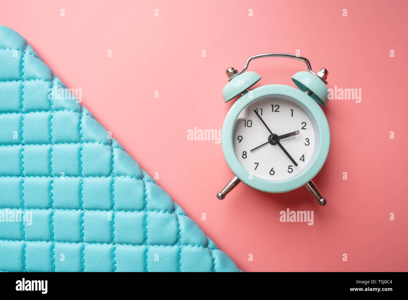 Blue analog metal alarm clock on stylish blue-pink background. The ...