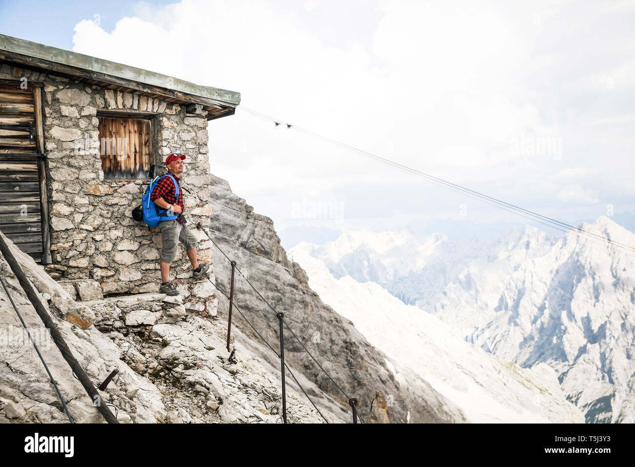 Austria, Tyrol, man on a hiking trip standing at mountain hut Stock ...