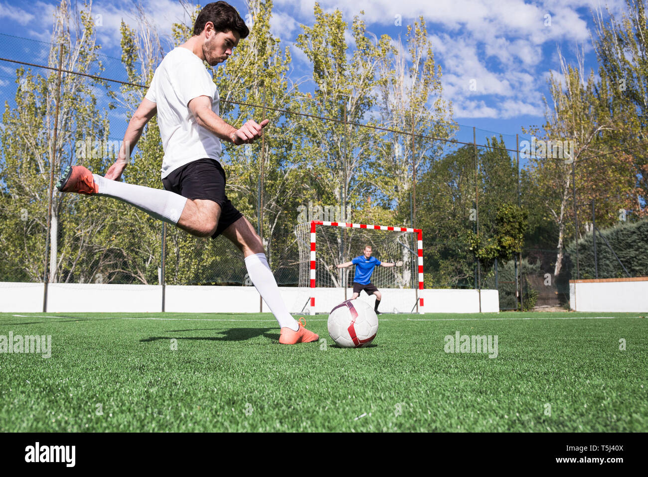 Football player shooting the ball on football field Stock Photo - Alamy