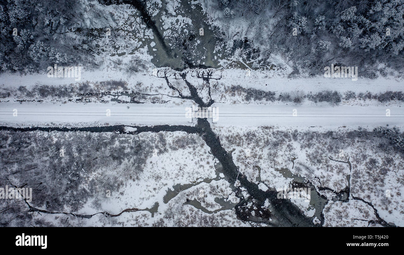 frozen creek running under a single railroad track Stock Photo - Alamy