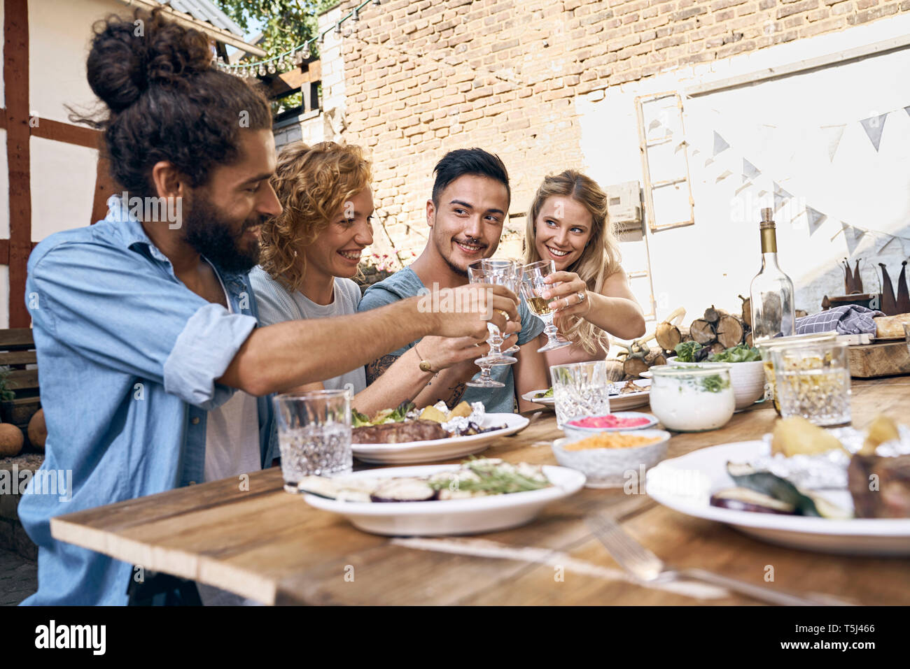 Friends having fun at a barbecue party, eating together Stock Photo - Alamy