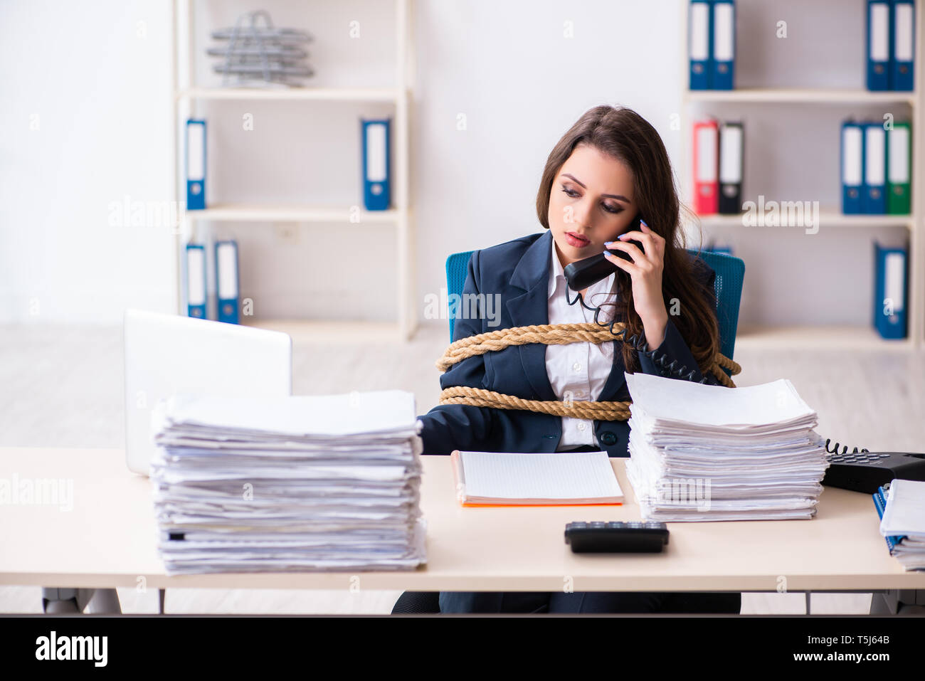 Young beautiful employee tied up with rope in the office Stock Photo ...