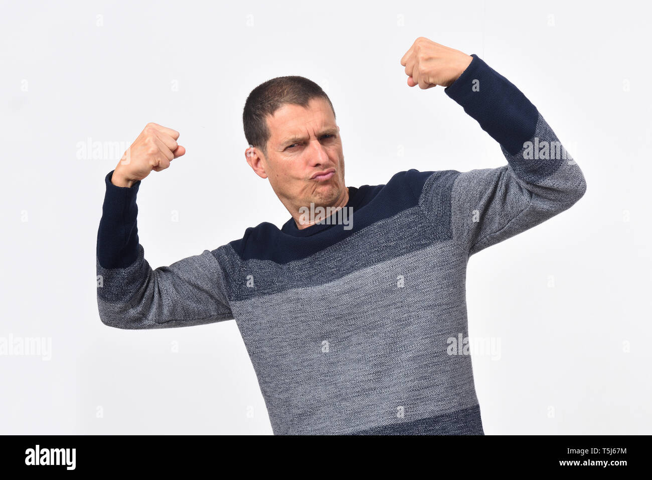 Man raising his arms making biceps and sign of victory and strength ...