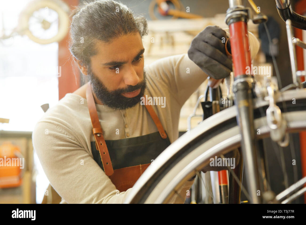 Man working in cycle repair shop Stock Photo - Alamy