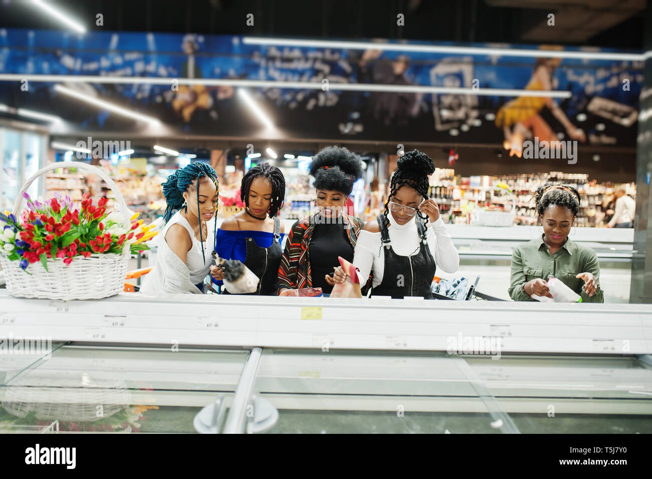 Group of african womans with shopping carts near refrigerator choose ...