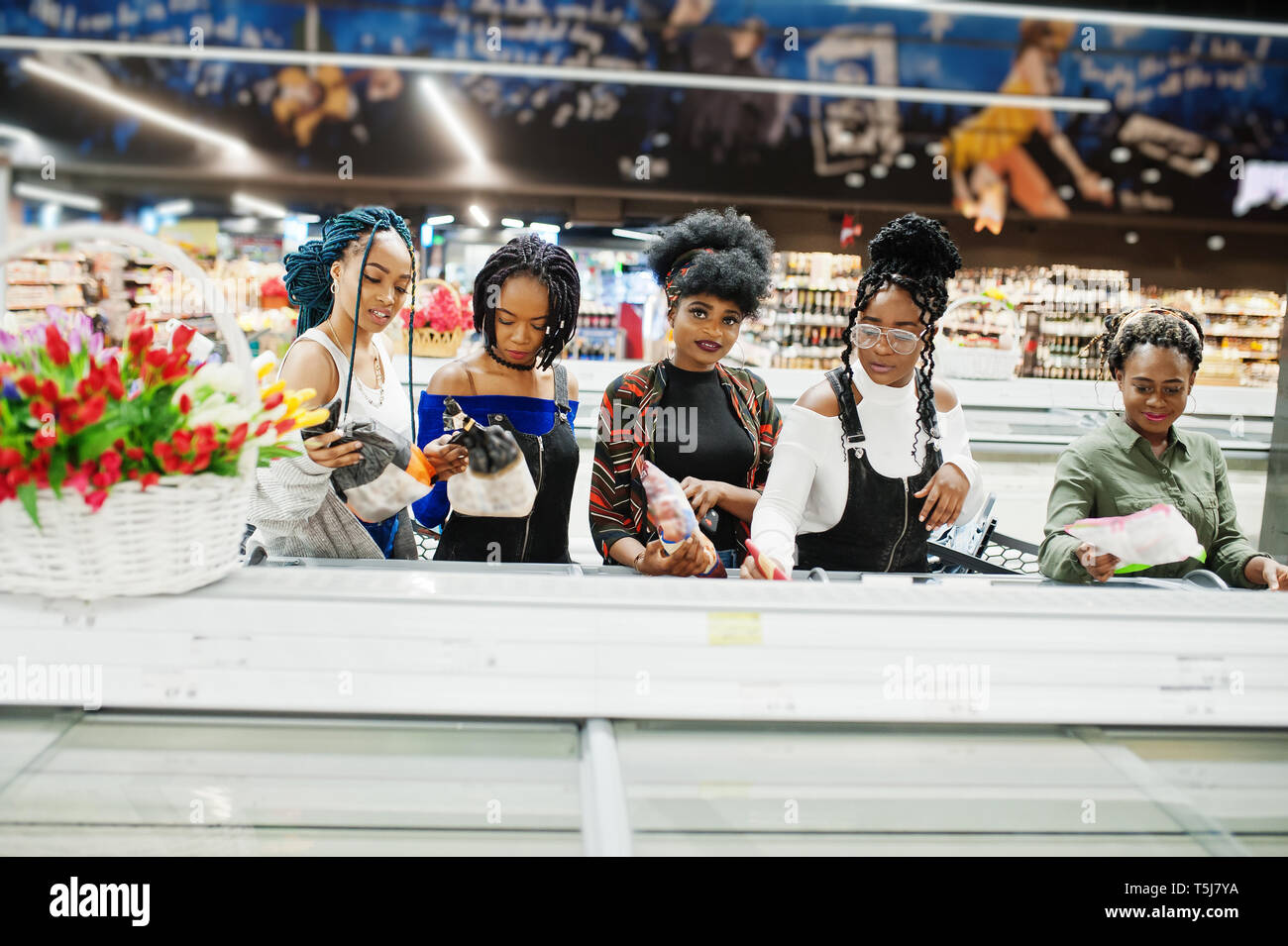 Group of african womans with shopping carts near refrigerator choose ...