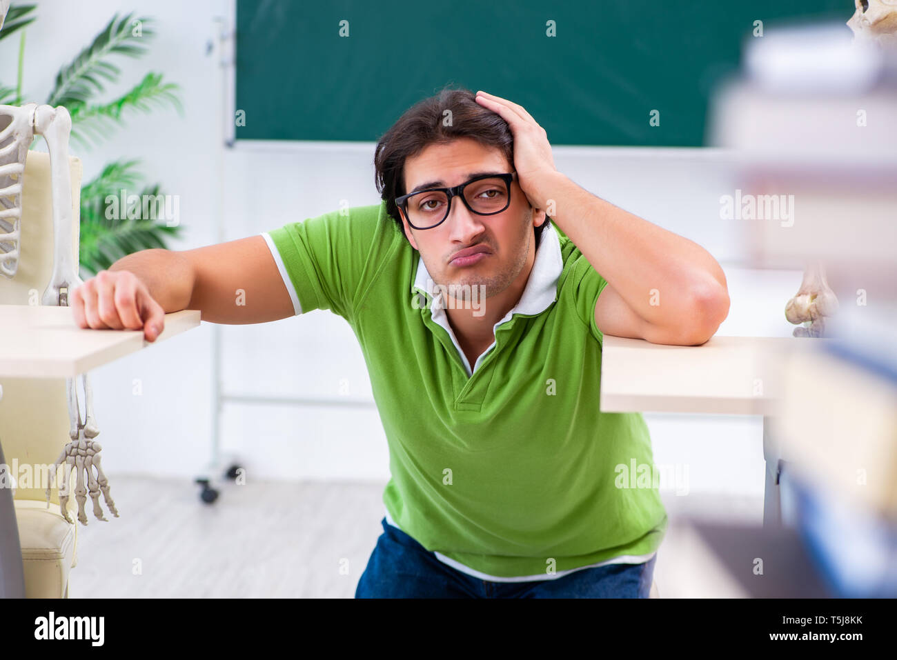 Funny male student in the classroom with skeleton Stock Photo - Alamy