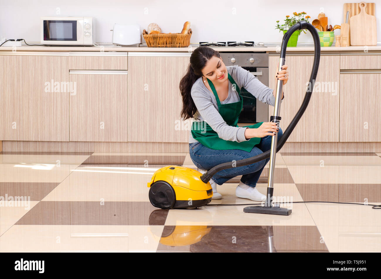 Young female contractor doing housework Stock Photo - Alamy