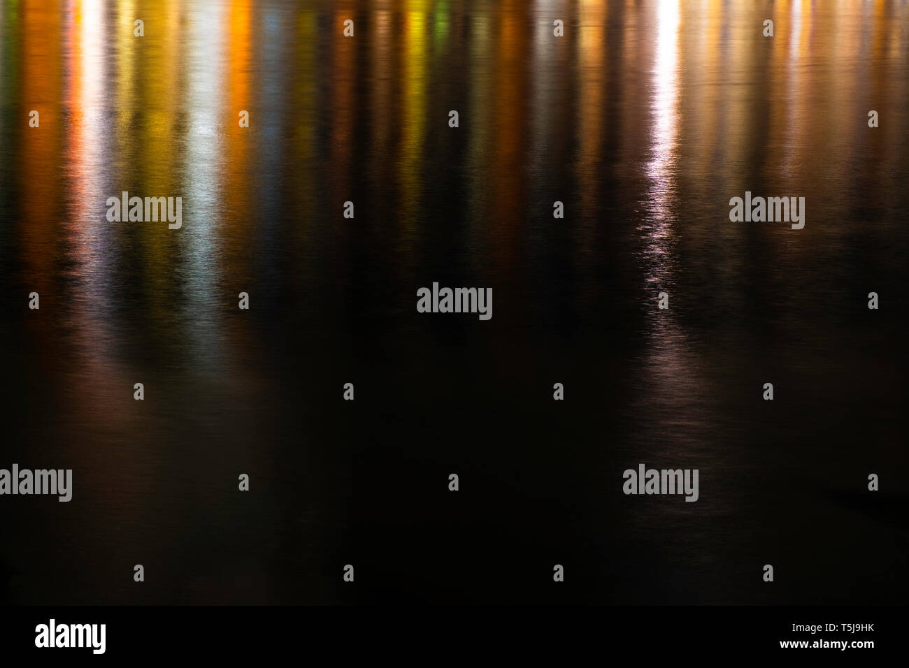 Colorful lights reflecting on water in night time background - Linear ...