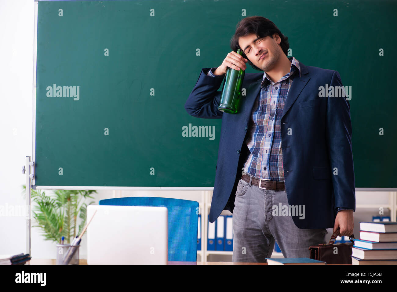 Male teacher drinking in the classroom Stock Photo - Alamy