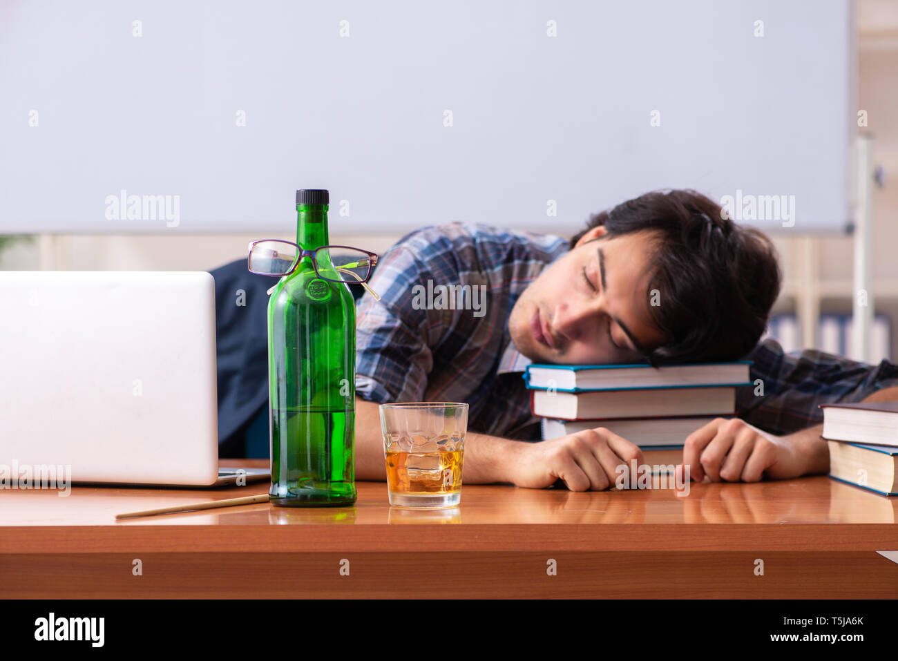 Male teacher drinking in the classroom Stock Photo - Alamy