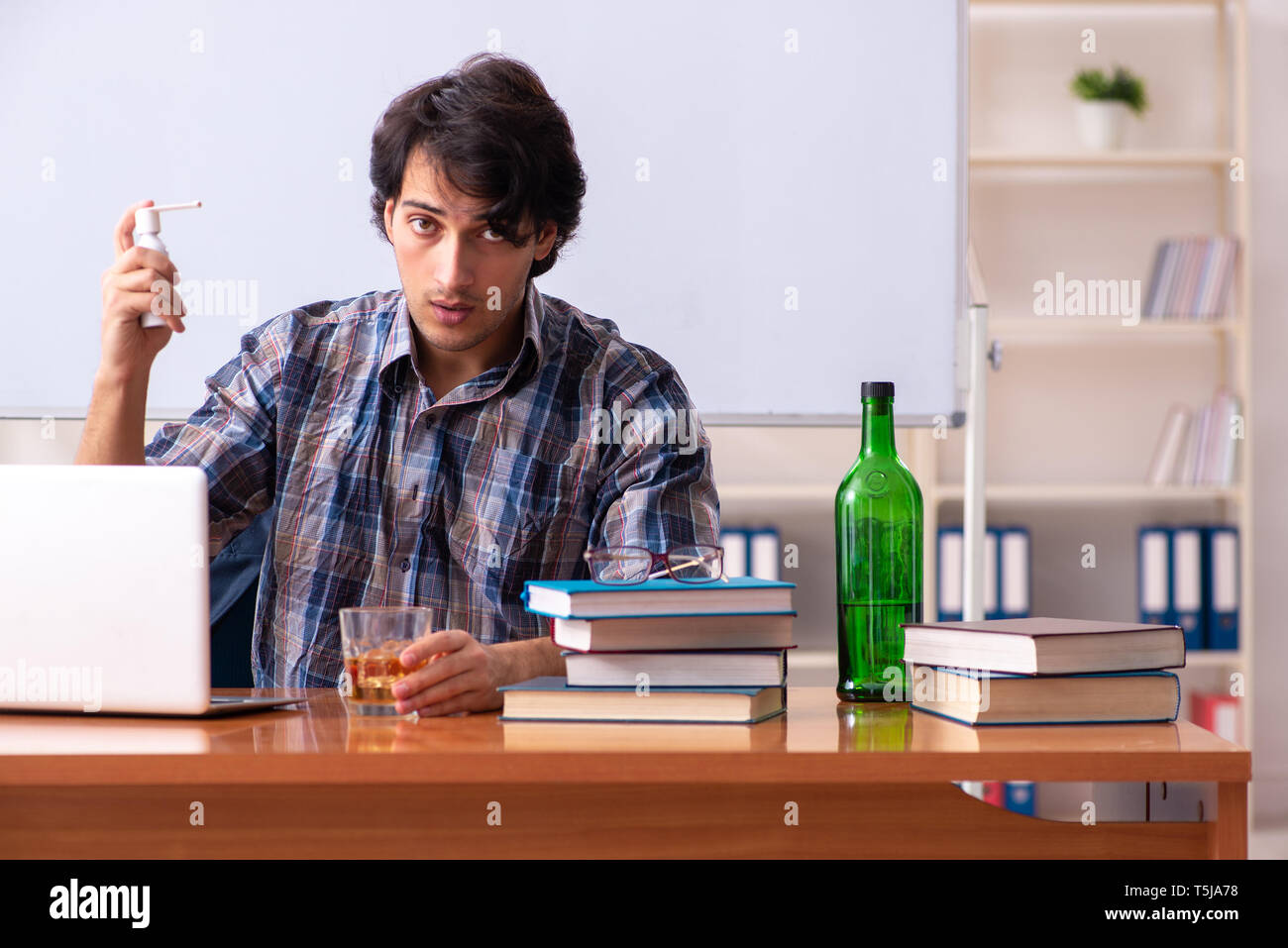 Male teacher drinking in the classroom Stock Photo - Alamy