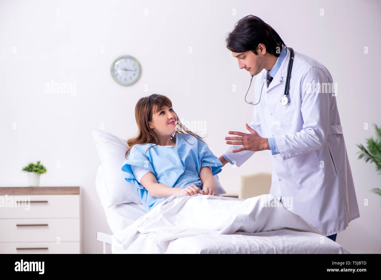 Male doctor visiting female patient in ward Stock Photo - Alamy