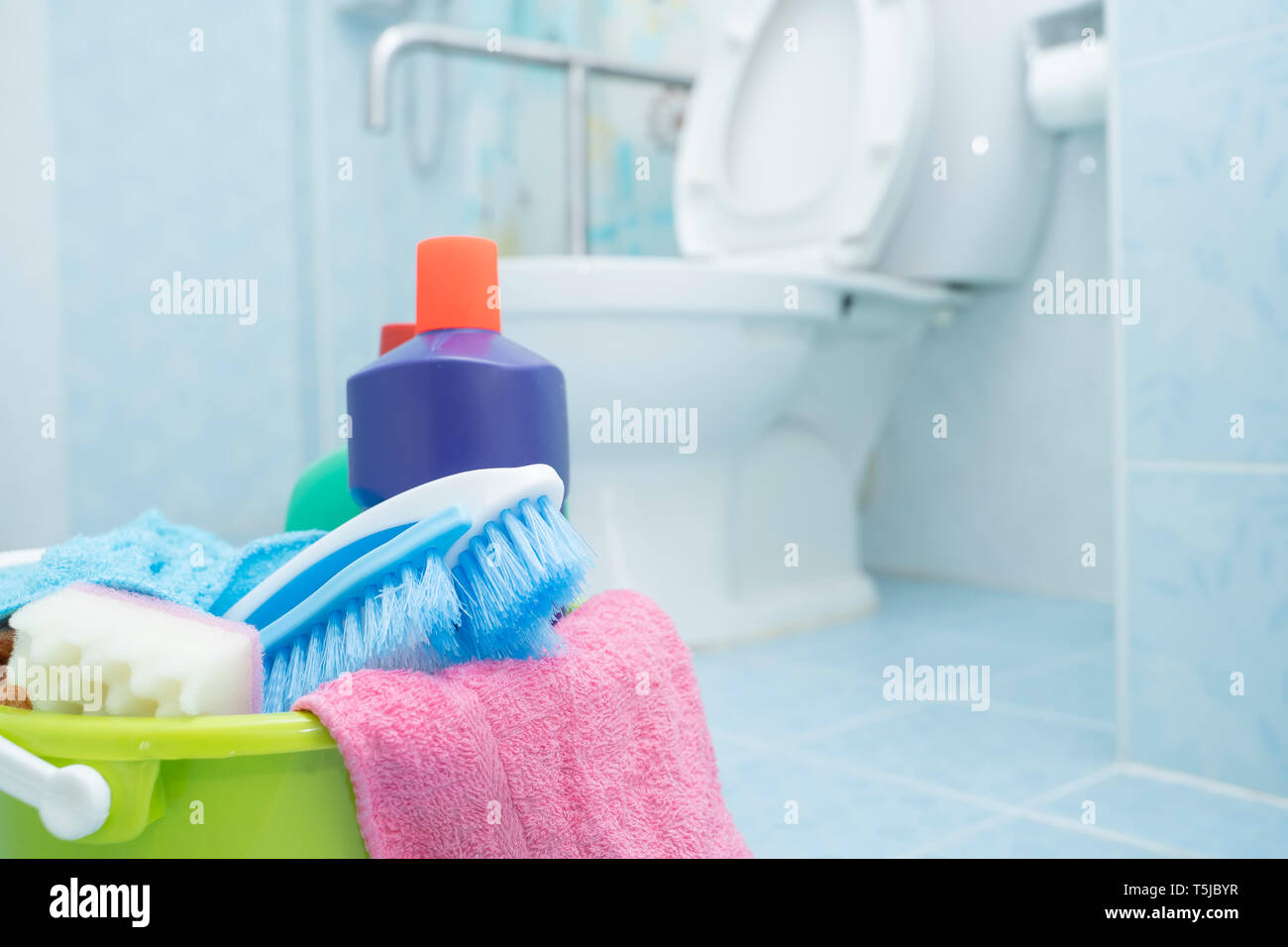 Cleaning with a bucket and cleaning products on blurred background ...