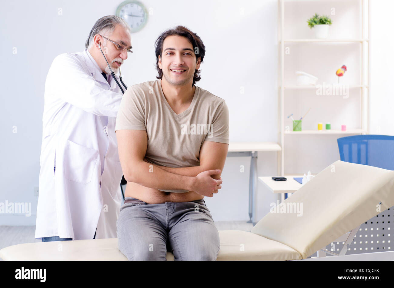 Young male patient visiting old doctor Stock Photo - Alamy