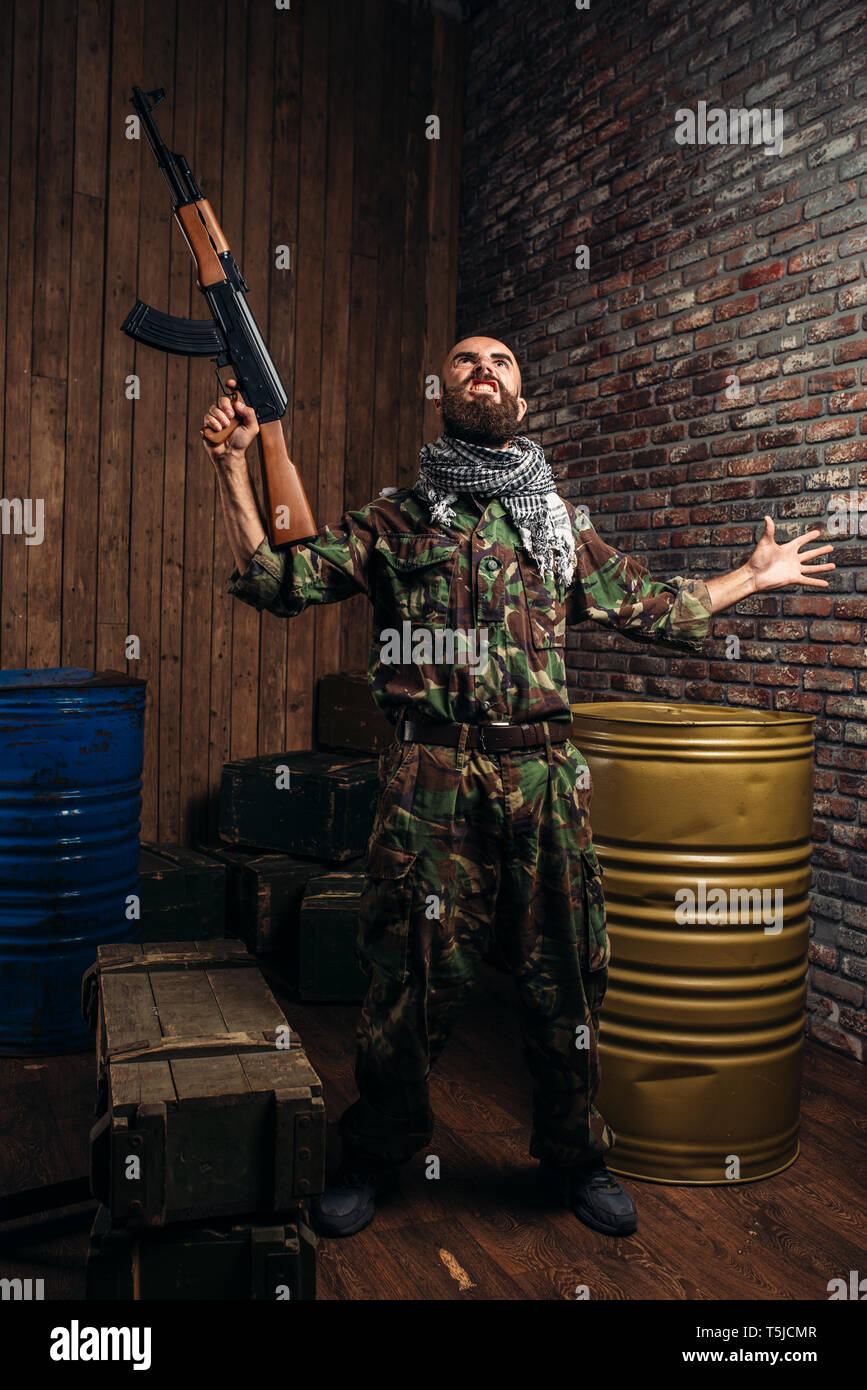 Bearded terrorist holding the kalashnikov rifle up. Terrorism and ...