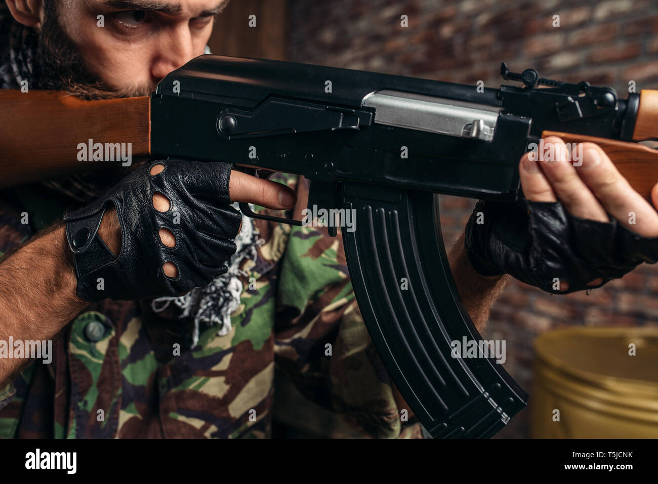 Cruel terrorist in uniform aiming from a kalashnikov rifle closeup, man ...