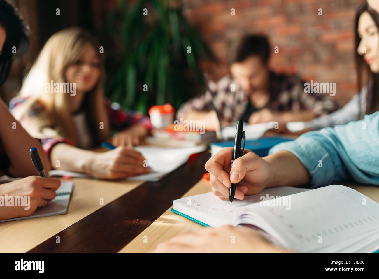 Group of highschool students prepares teamwork project. People studying ...