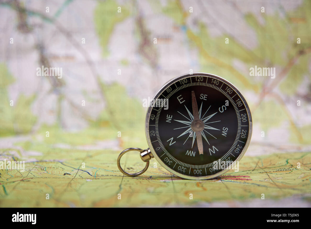 Detailed view of compass and tourist map with defocused background and ...