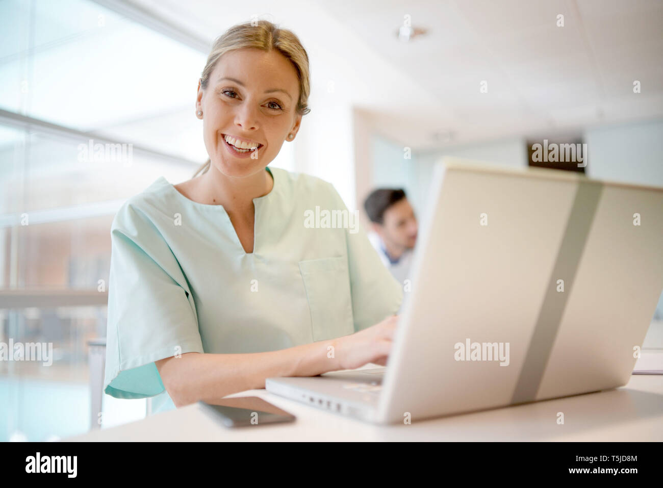 Nurse smiling at camera in hospital office Stock Photo - Alamy