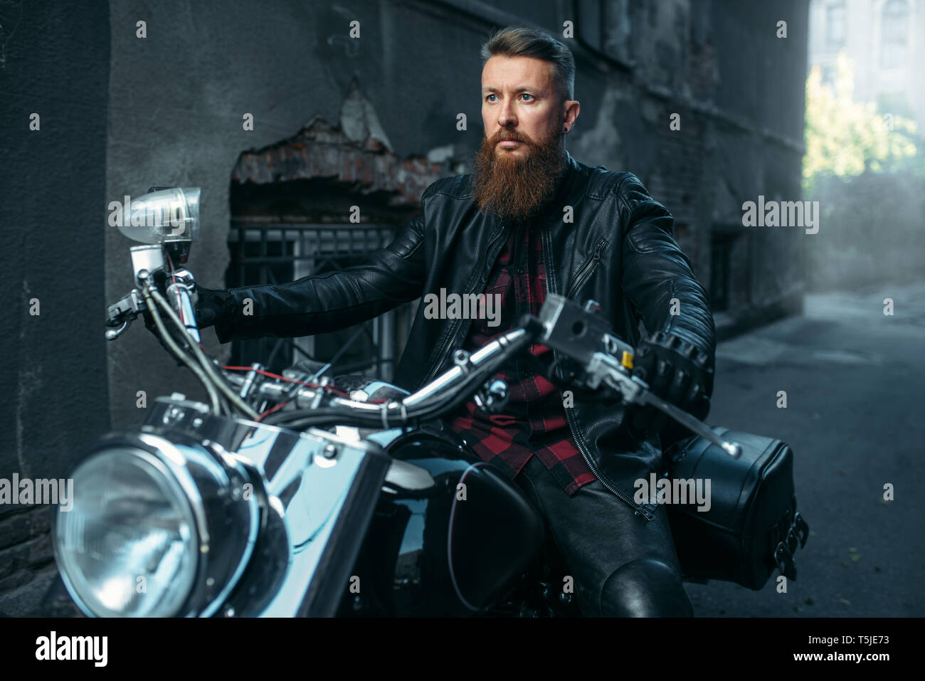 Motorcyclist in leather jacket poses on classical chopper. Vintage bike ...