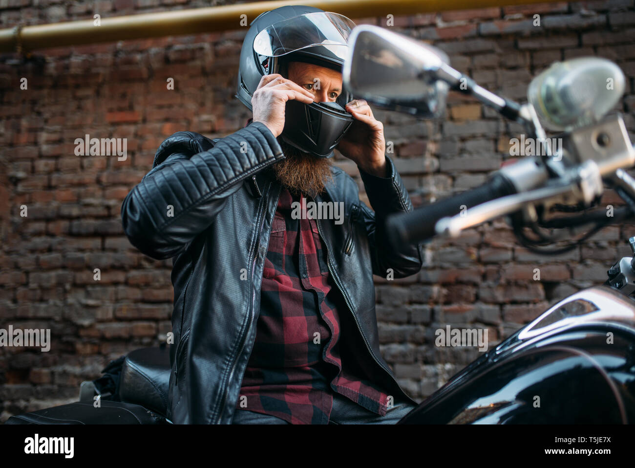Biker puts on helmet before riding on classical chopper. Vintage bike ...