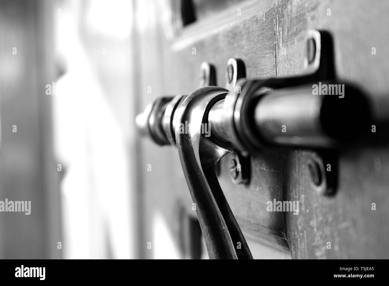 Rusted aldrop door lock on a door in Black and white close-up view ...