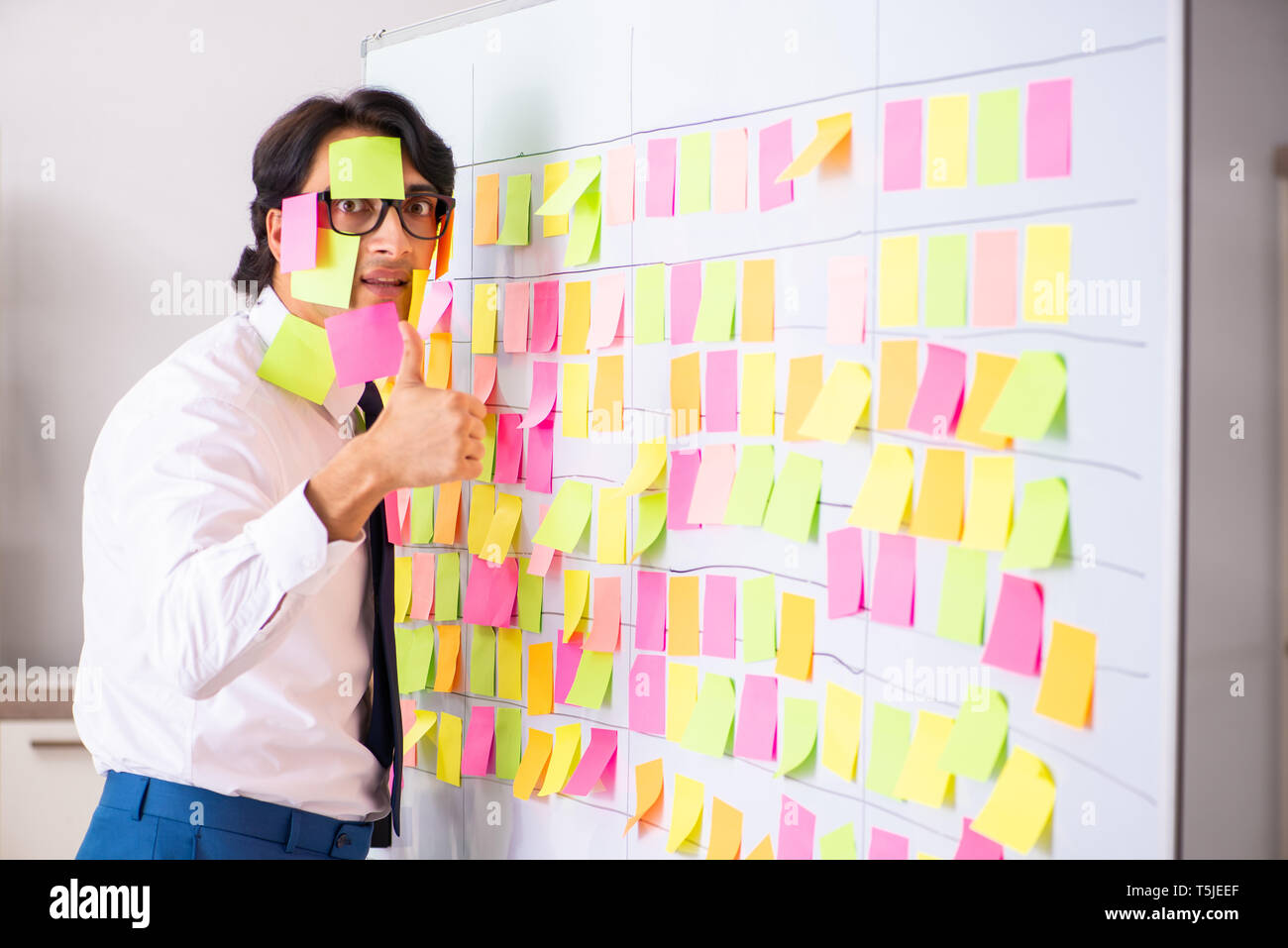 Young employee in conflicting priorities concept Stock Photo - Alamy