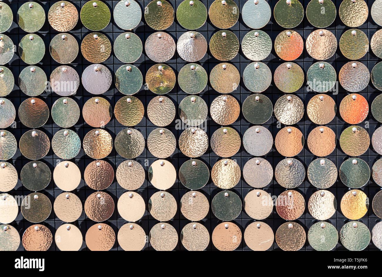 Background from small round metal plates of golden color. Golden ...