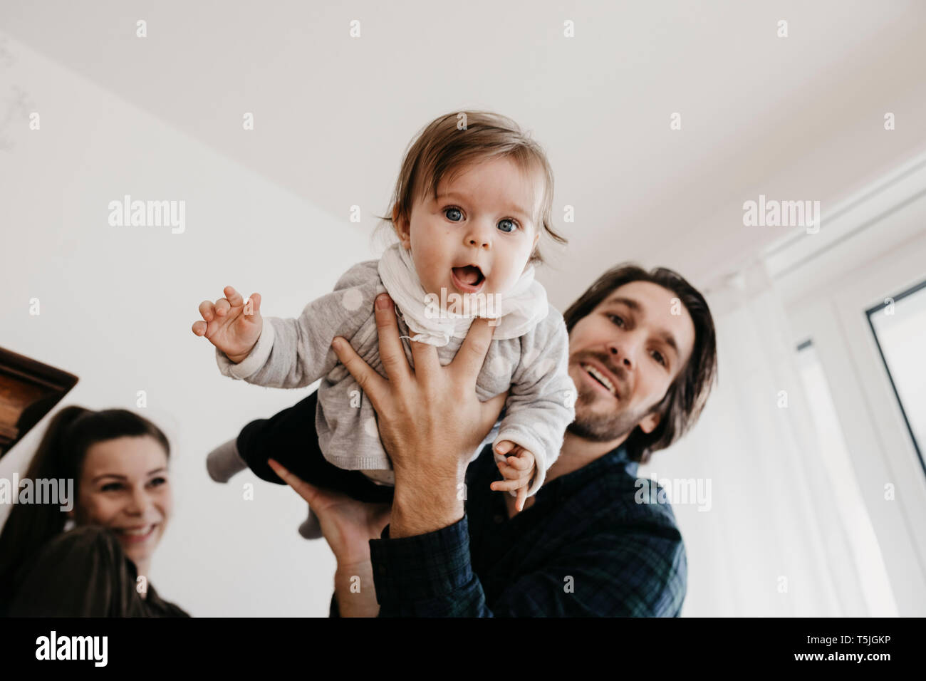 Happy family playing with baby girl at home Stock Photo - Alamy