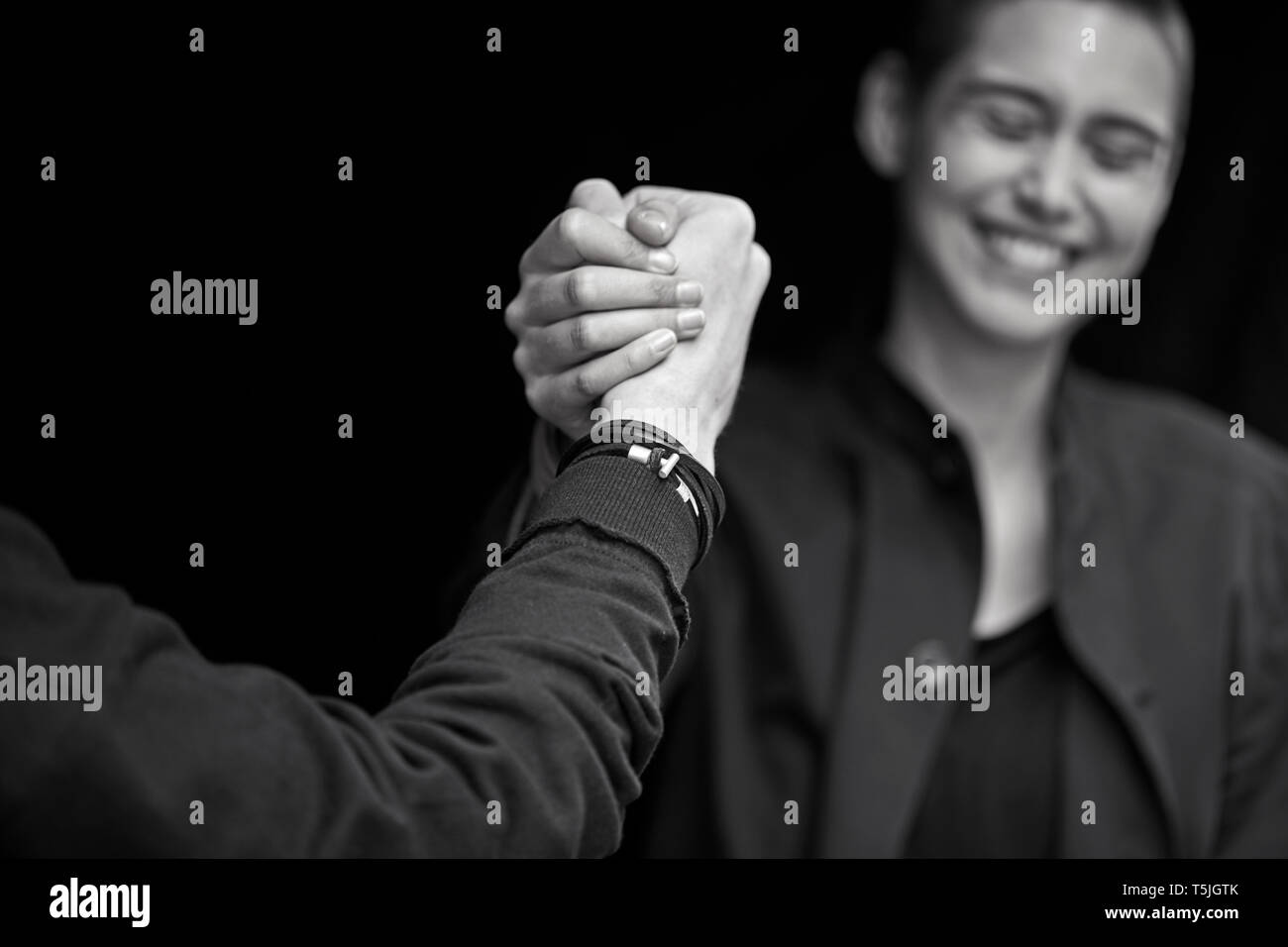 Young couple shaking hands Stock Photo - Alamy