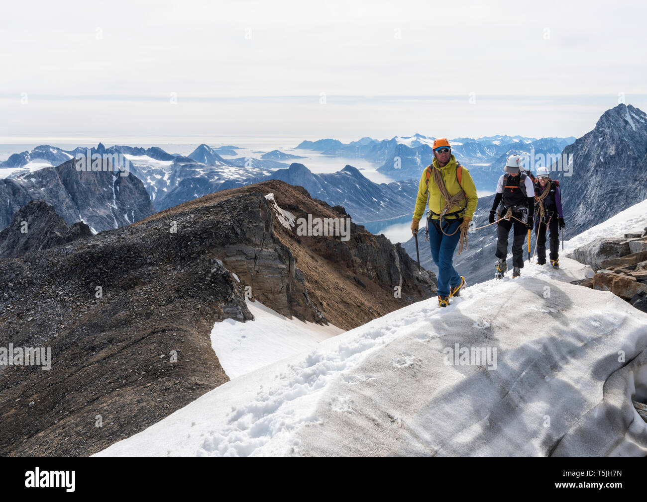 Greenland, Sermersooq, Kulusuk, Schweizerland Alps, mountaineers walking in snowy mountainscape ...