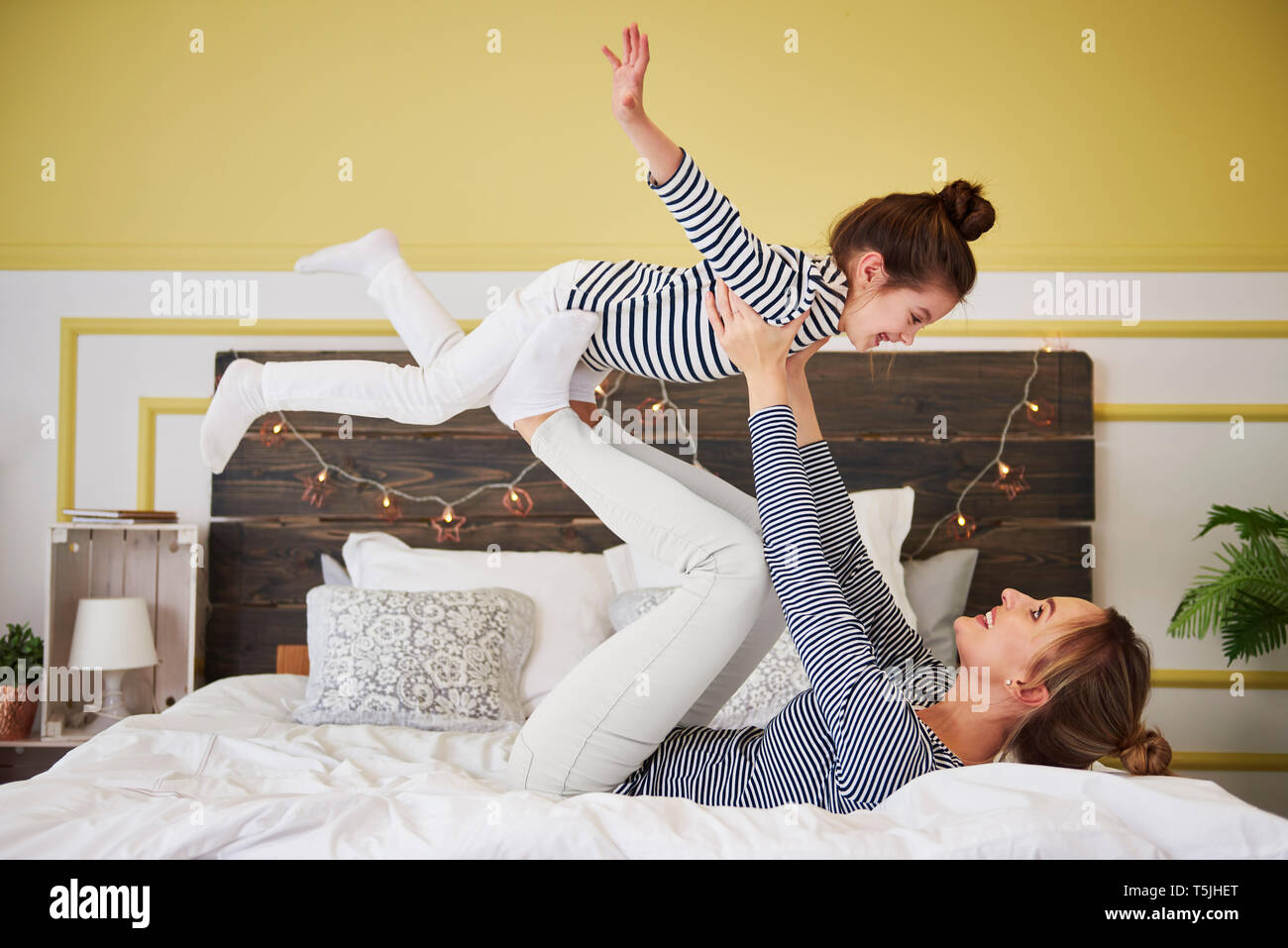 Mother and daughter playing on bed, pretending to fly Stock Photo - Alamy