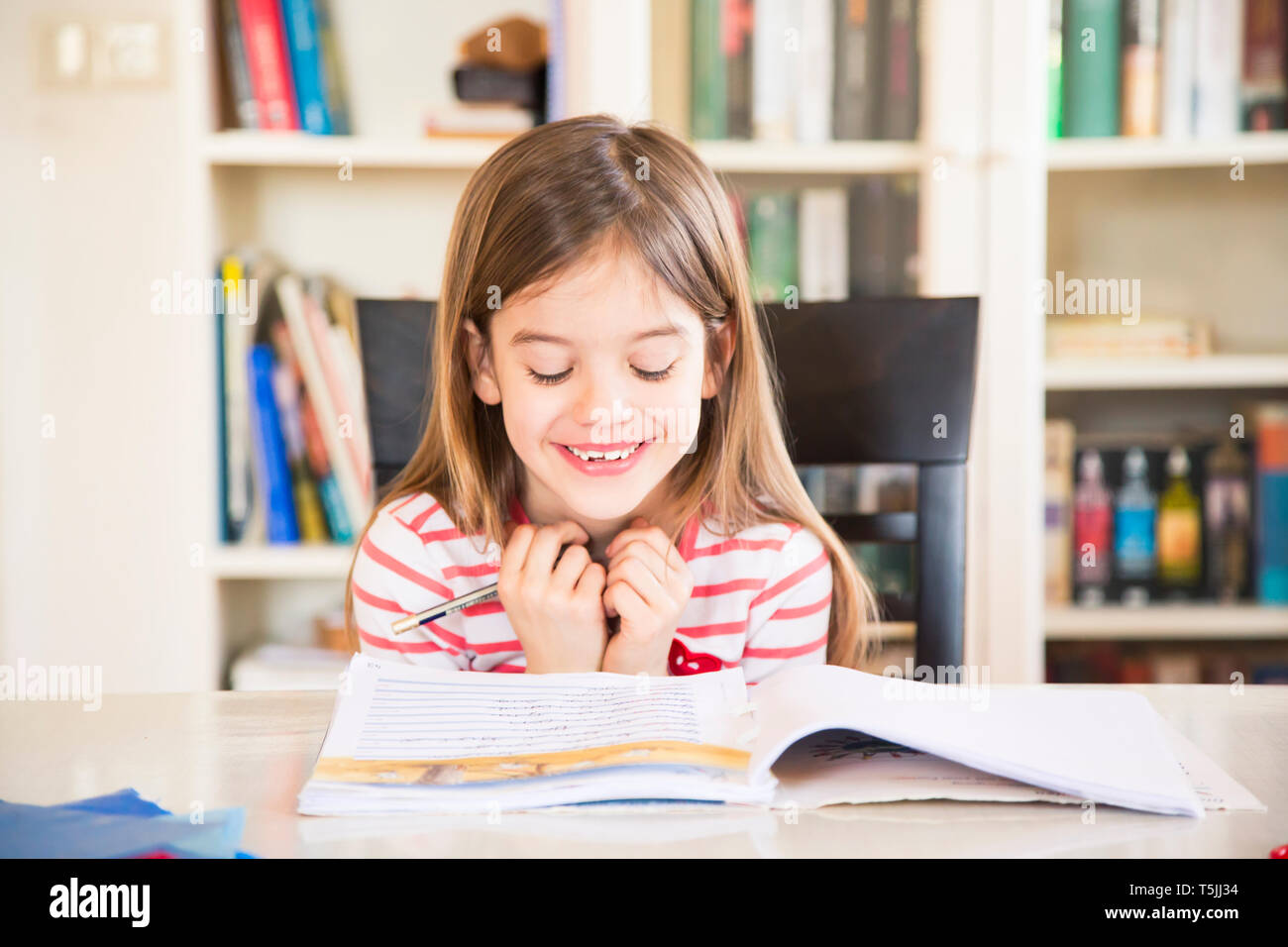 Portrait of happy little girl doing homework Stock Photo - Alamy